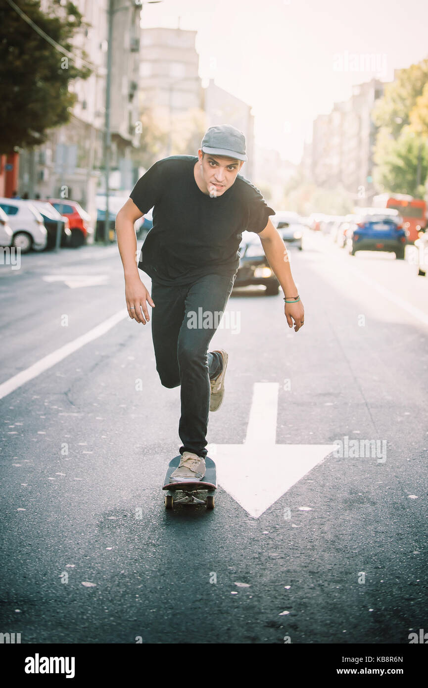 Pro skate rider ride skateboard in front of the car on the city road ...