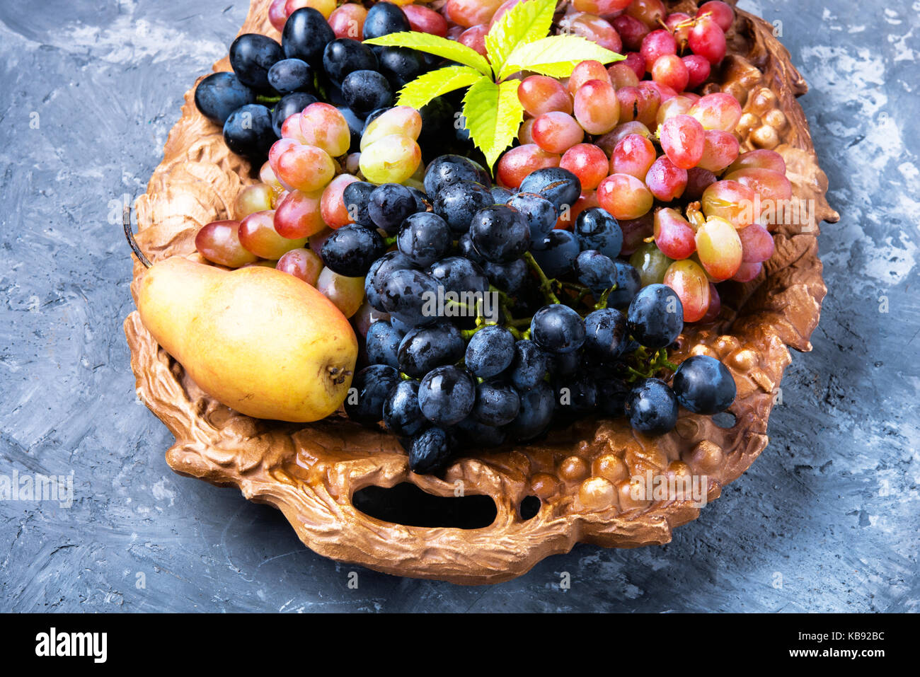 Harvest of autumn grapes and ripe pear on a tray Stock Photo - Alamy