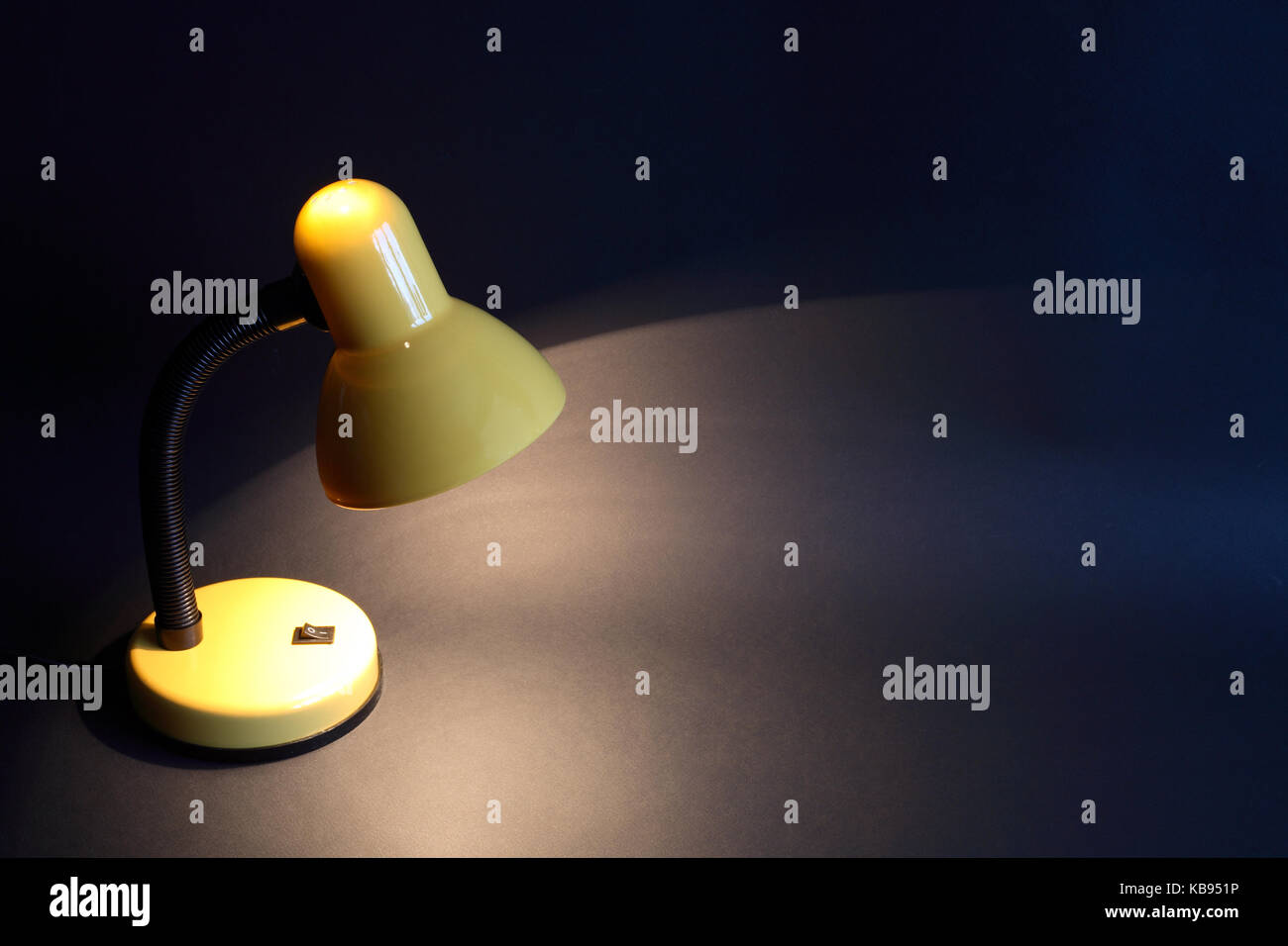 Modern yellow luminous desk lamp on dark background with copy space ...