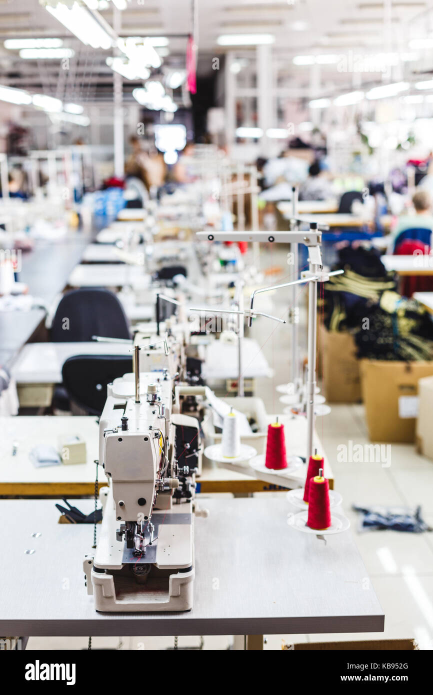 Interior of garment factory shop. Closes making atelier with several sewing machines. Tailoring ...