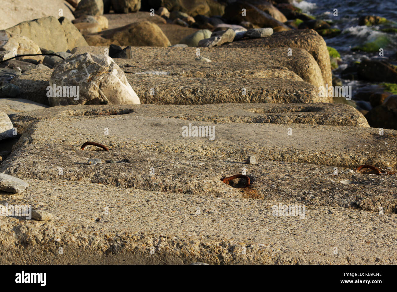 Large concrete rectangular blocks to protect the shore from erosion lie ...