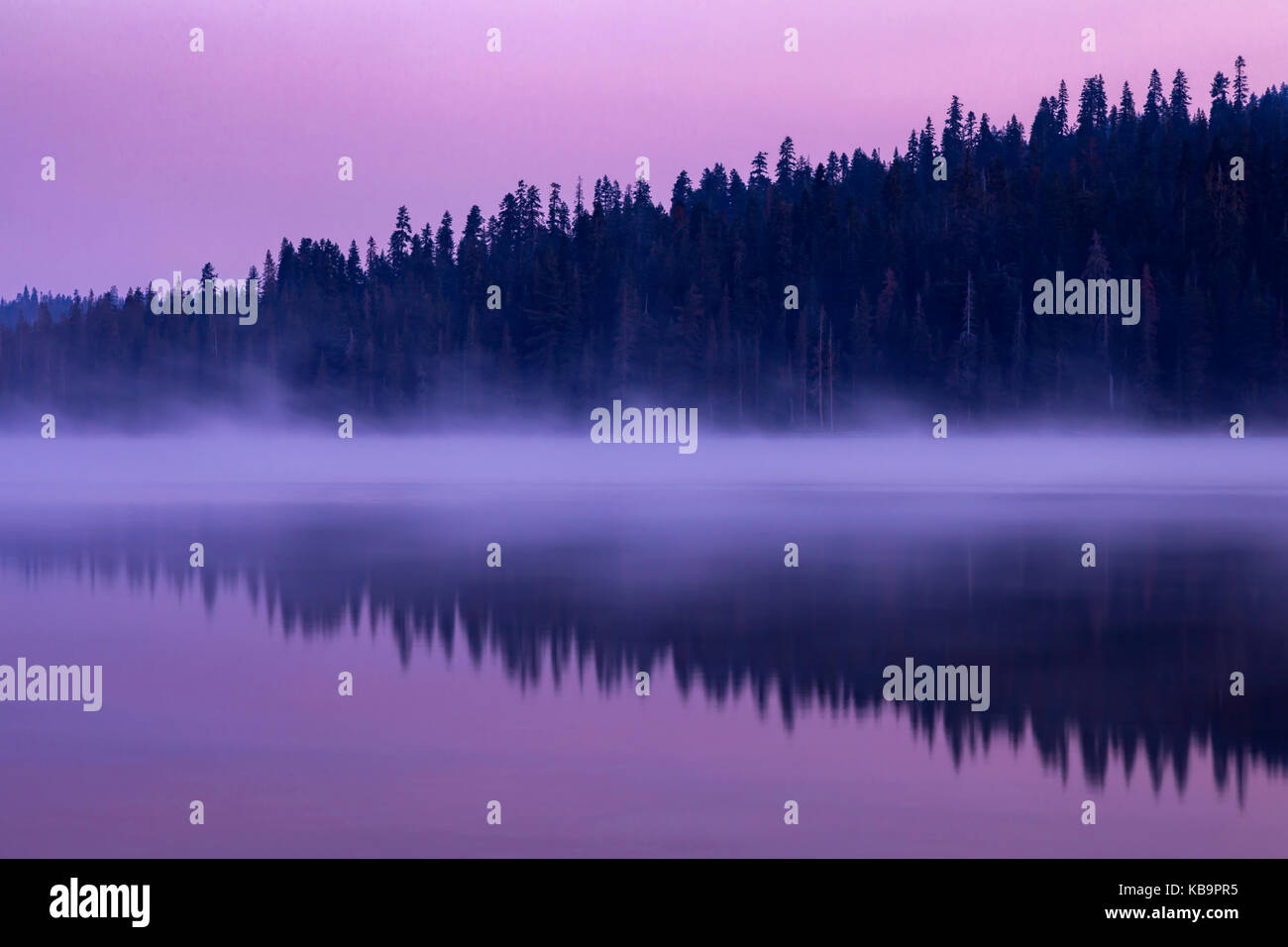 A shallow layer of fog hangs over Juniper Lake at dawn in Lassen ...