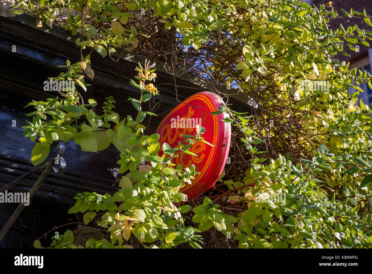 Village Royal Mail post office sign in an overgrown honeysuckle ...