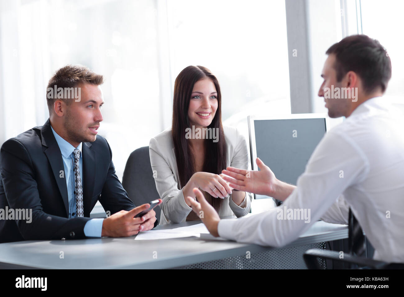 Business team conducts an interview with a young candidate,sitting at ...