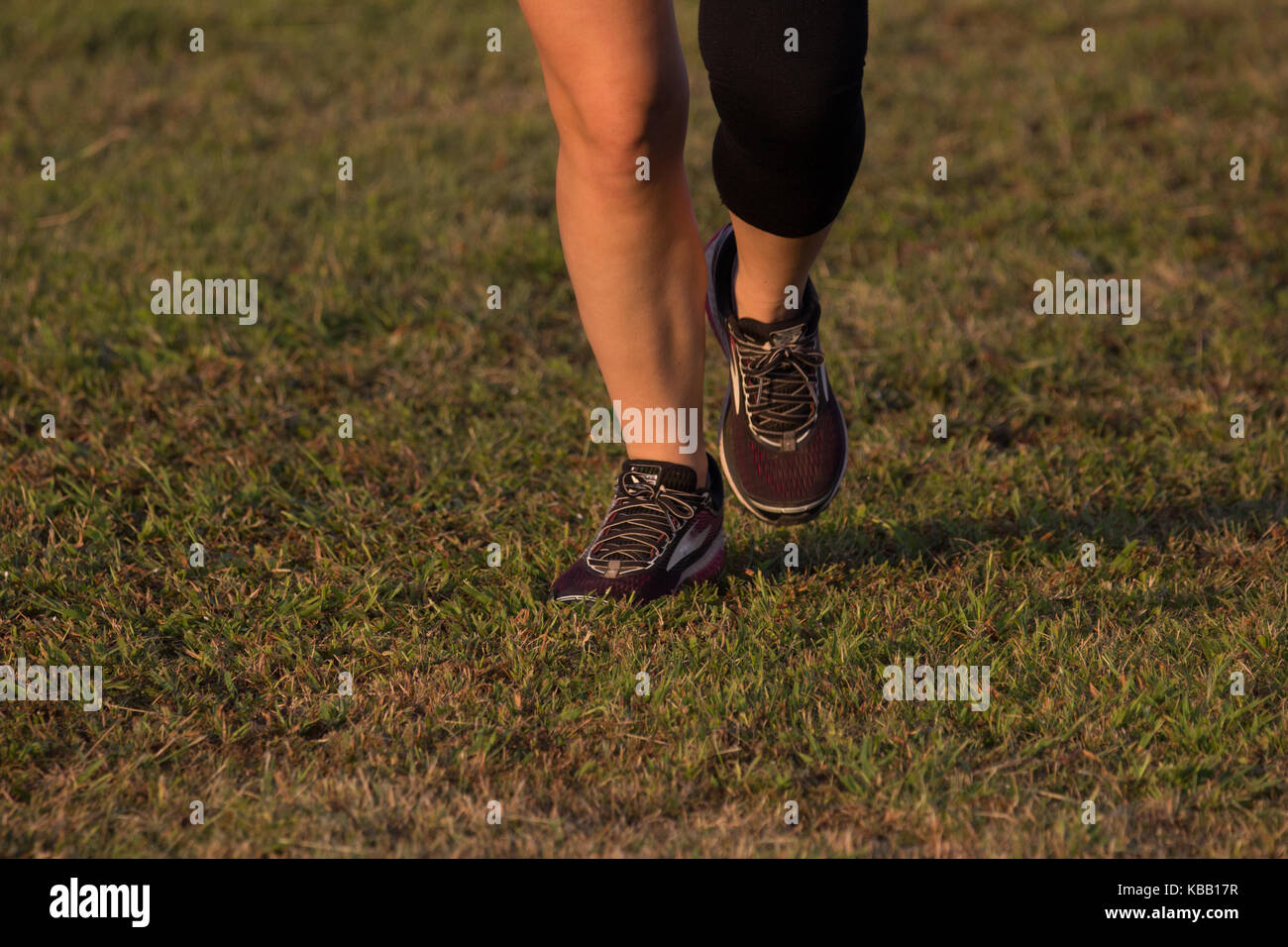 Girl running on grass filed in cross country competition Stock Photo ...
