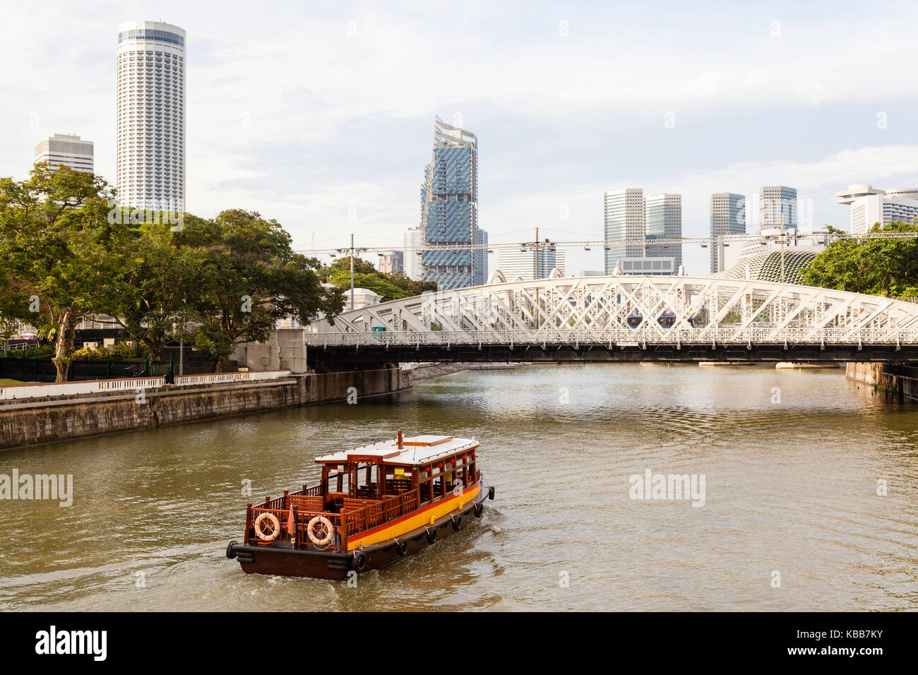 A boat ply the Singapore River on Boat Quay toward Anderson Bridge ...
