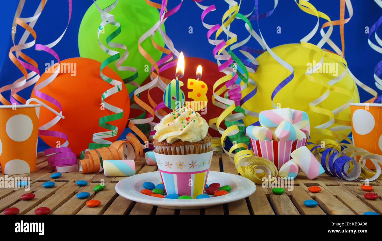 63 Birthday cupcake with candles burning on rustic wooden table with ...