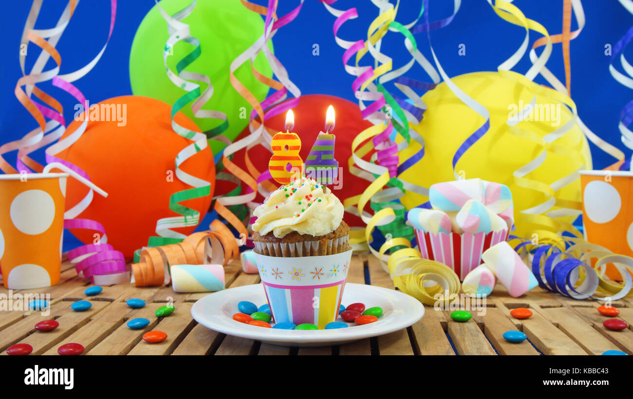 84 Birthday cupcake with candles burning on rustic wooden table with ...