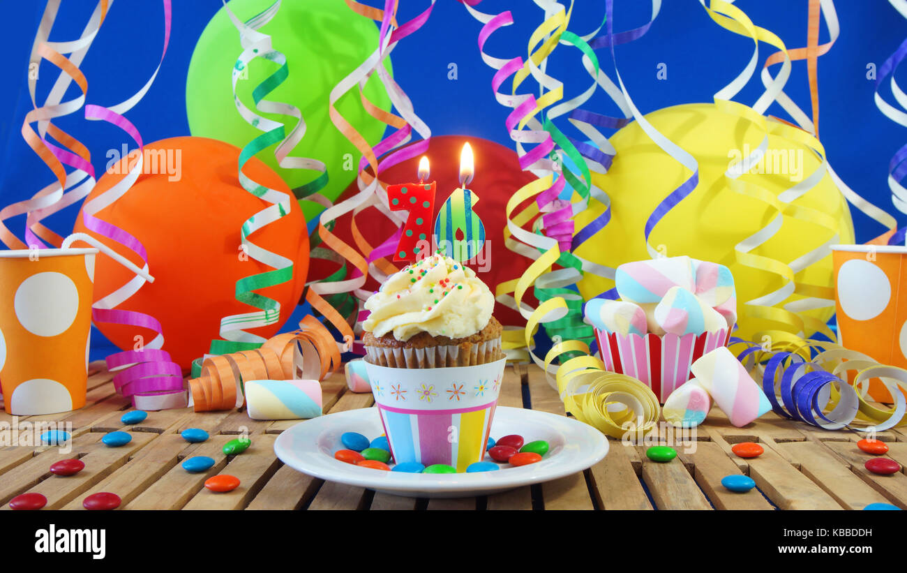 76 Birthday cupcake with candles burning on rustic wooden table with ...