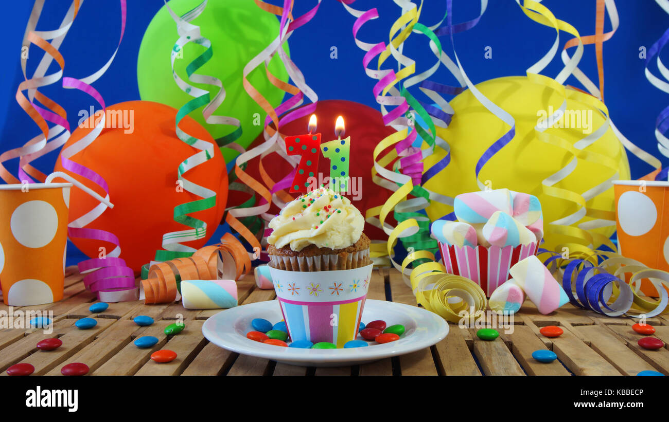 71 Birthday cupcake with candles burning on rustic wooden table with ...