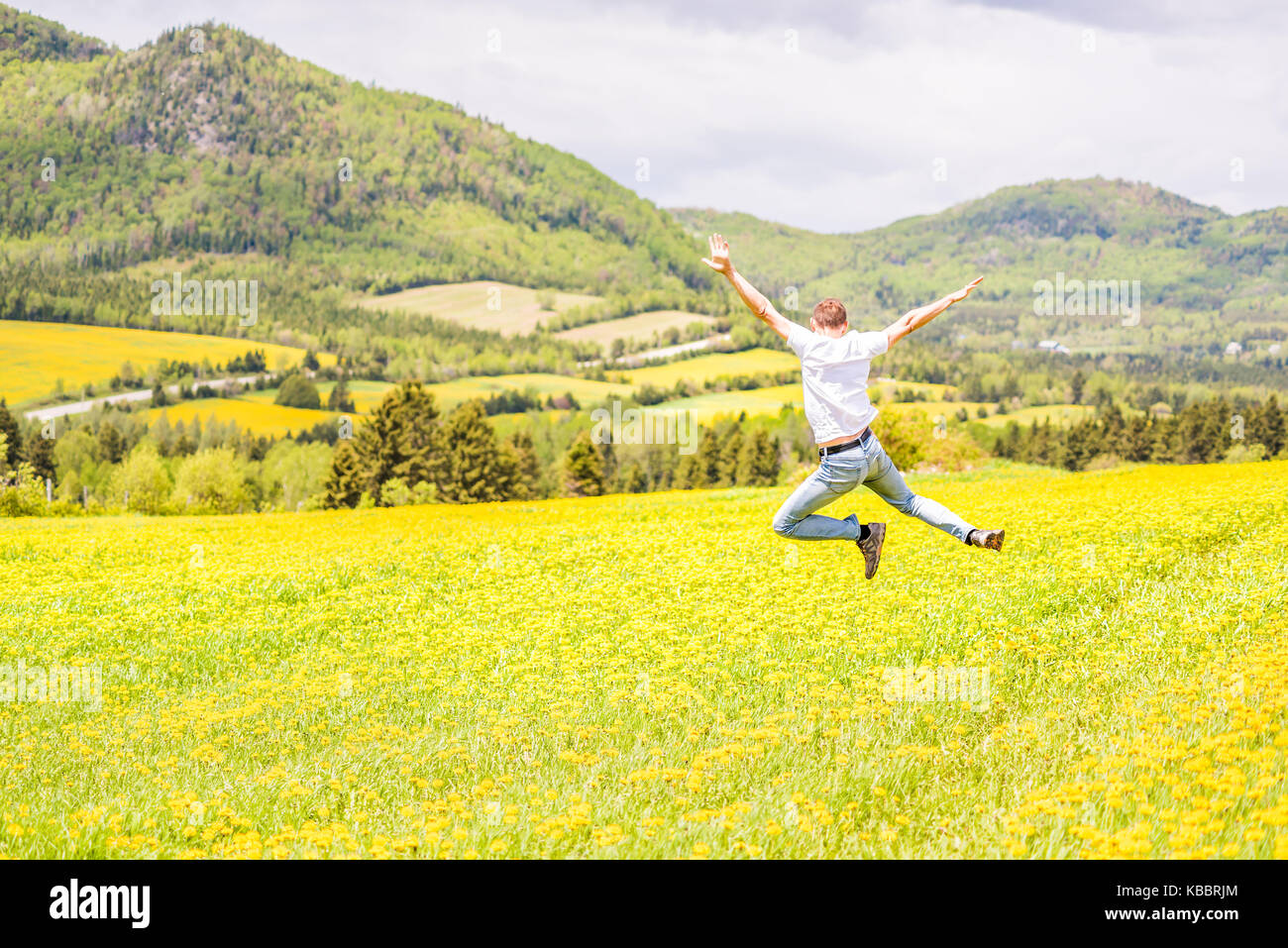 Young man, male running, jumping, hanging in air, mid-air and smiling ...