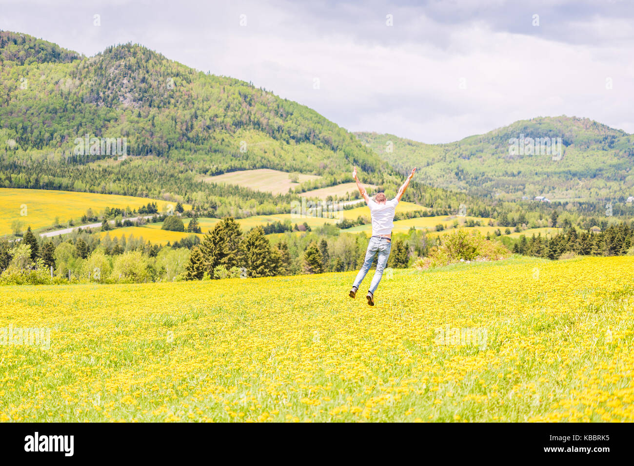 Young man, male running, jumping, hanging in air, mid-air and smiling ...