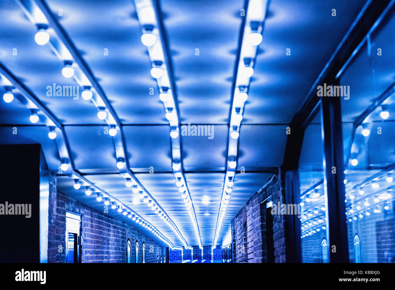 Blue illuminated alley with lights in evening passage in downtown ...