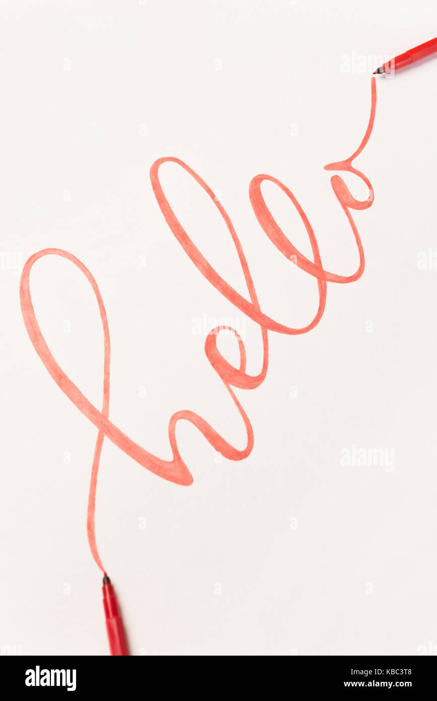 Greeting phrase 'Hello' handwritten with orange marker on white paper ...