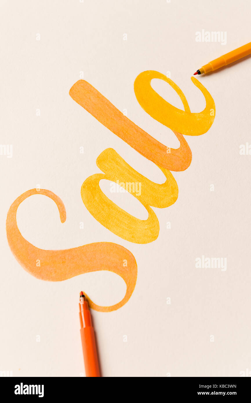 Side view of hand written calligraphy lettering 'Sale' with orange ...