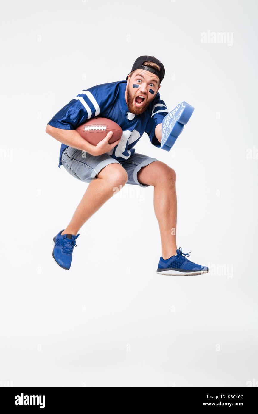 Image of screaming man fan in blue t-shirt jumping isolated over white ...