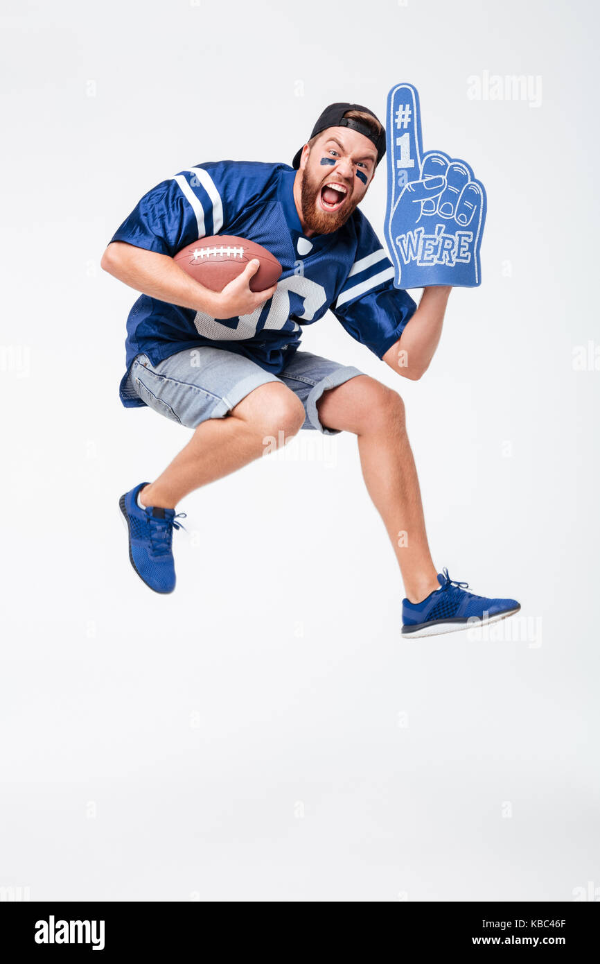 Image of screaming man fan in blue t-shirt jumping isolated over white ...