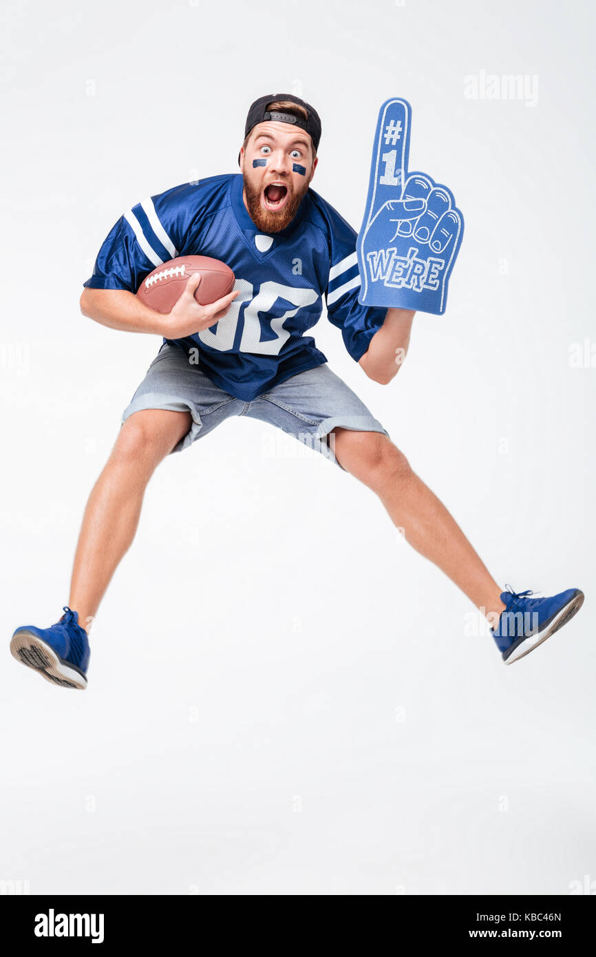 Image of screaming man fan in blue t-shirt jumping isolated over white ...