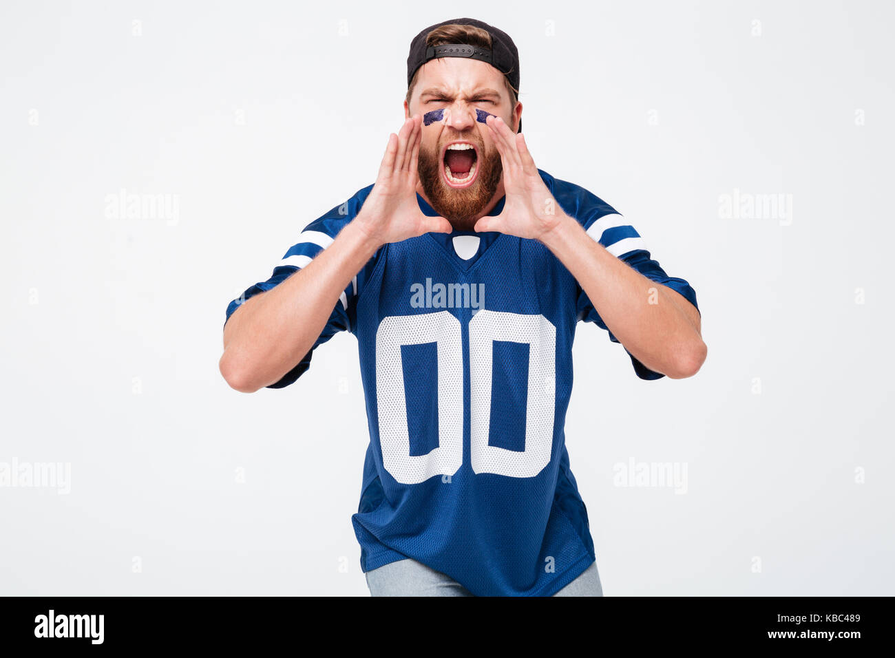 Screaming emotional man fan in blue t-shirt standing isolated over ...