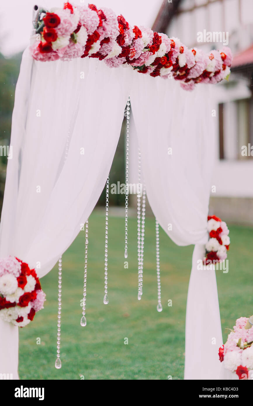 Side view of the wedding arch decorated with colourful flowers and ...