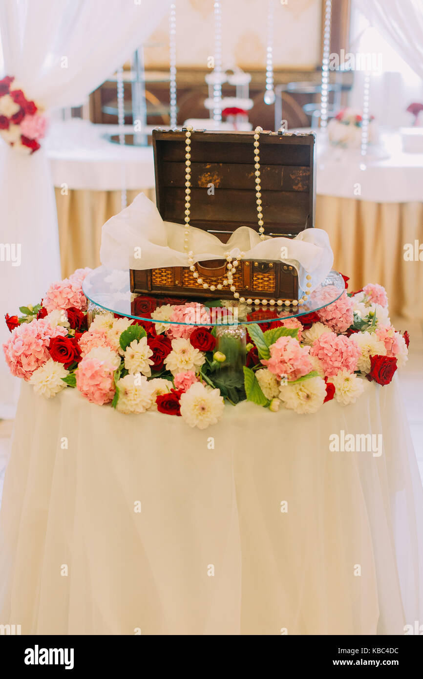 Wedding wooden box decorated with beads placed on the table covered ...