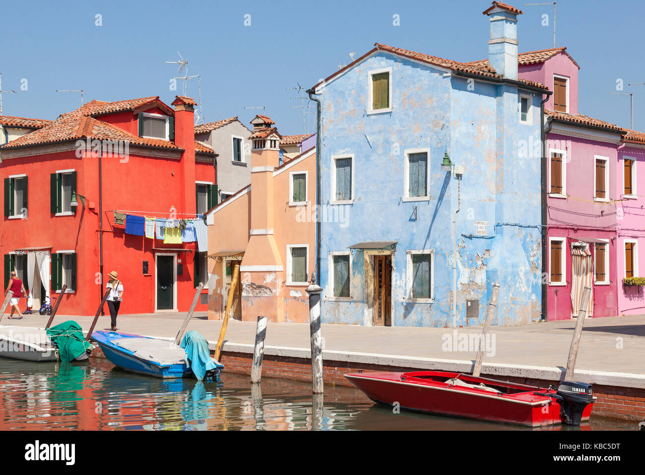 Burano, Venice, Veneto, Italy colorful old houses in the fishing village on a canal with boats ...