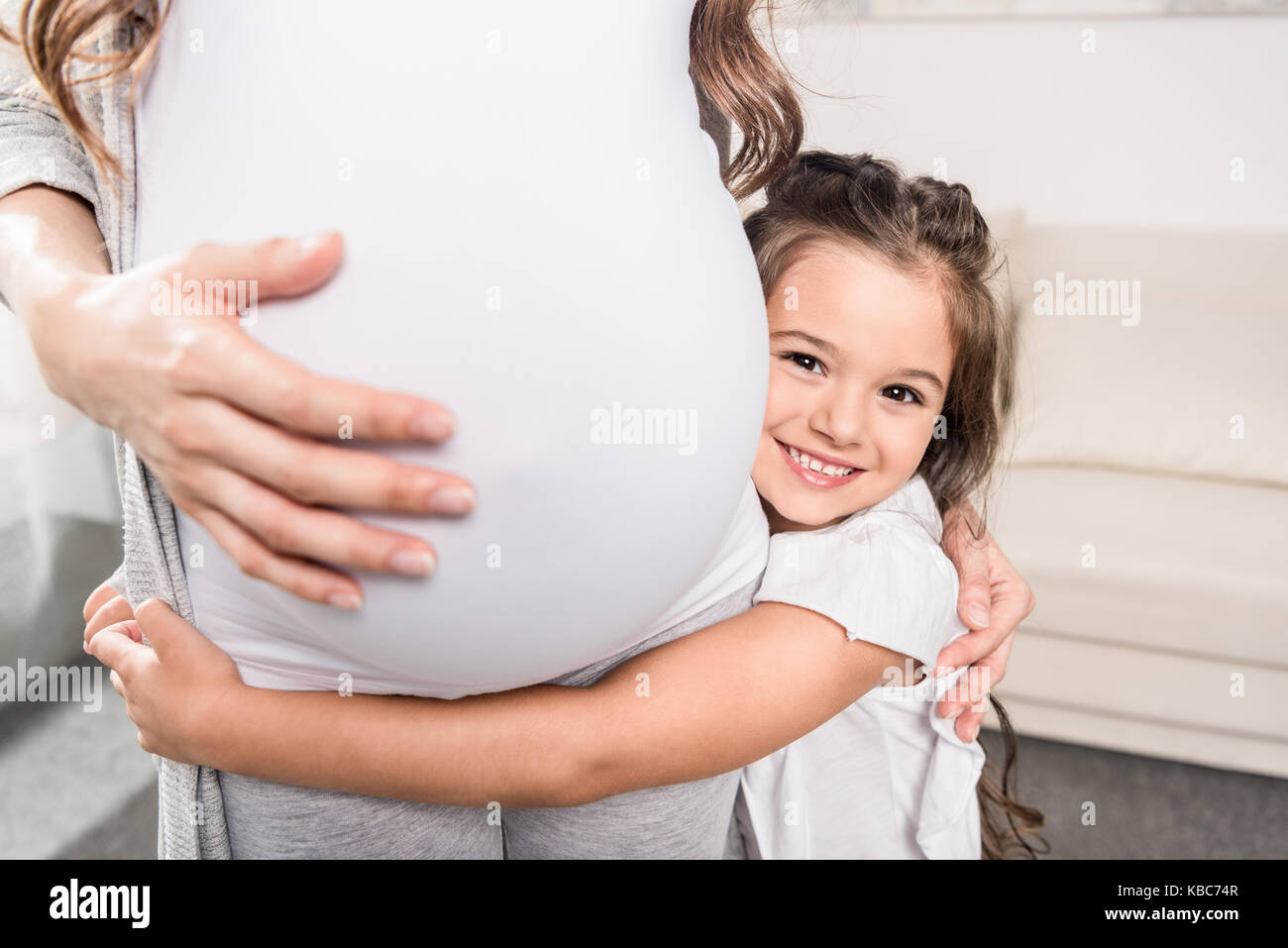 Girl hugging pregnant mother Stock Photo - Alamy