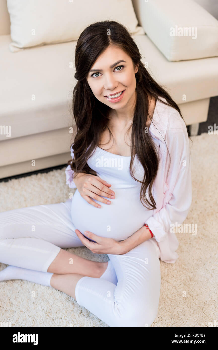 Pregnant woman sitting on floor Stock Photo - Alamy