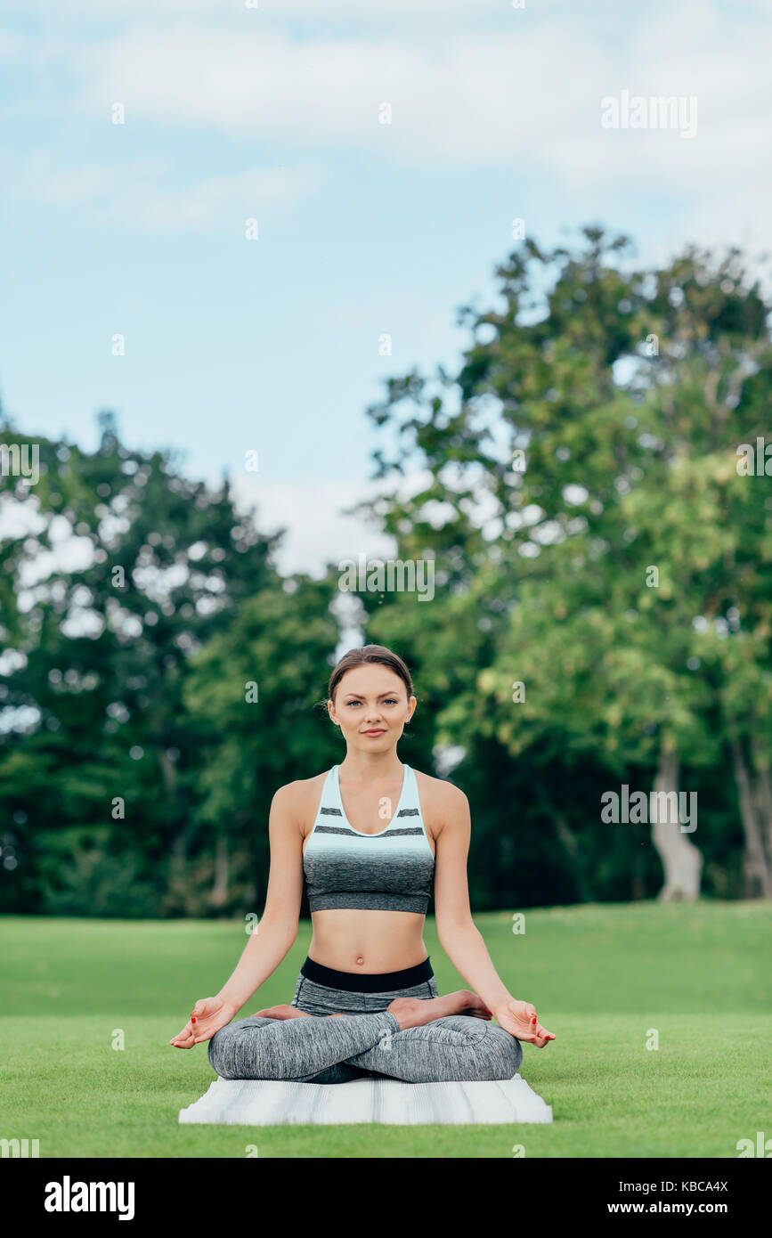 young woman performing lotus pose Stock Photo - Alamy