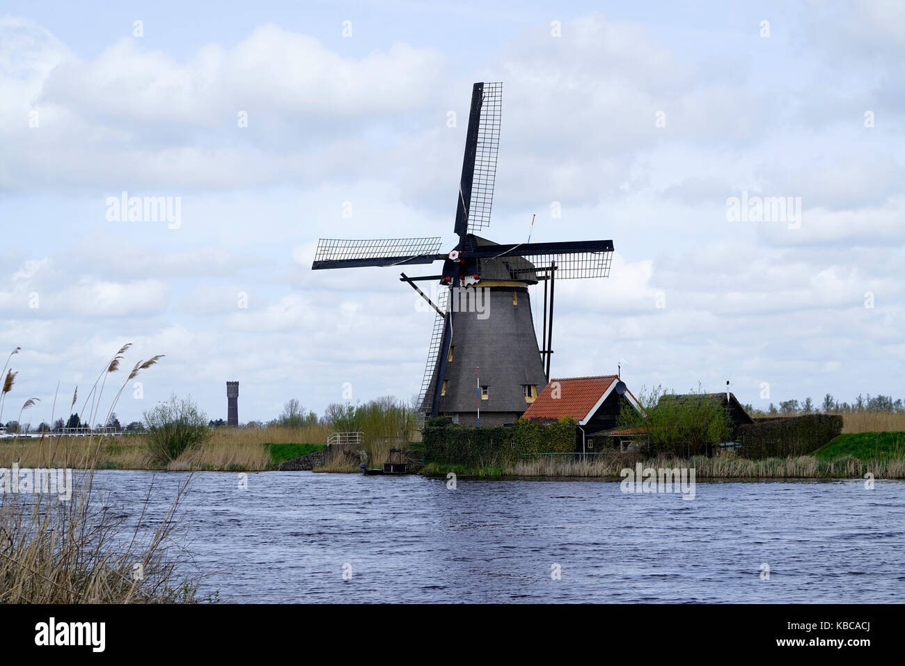 Dutch windmill in the afternoon build and standing next to polder water ...