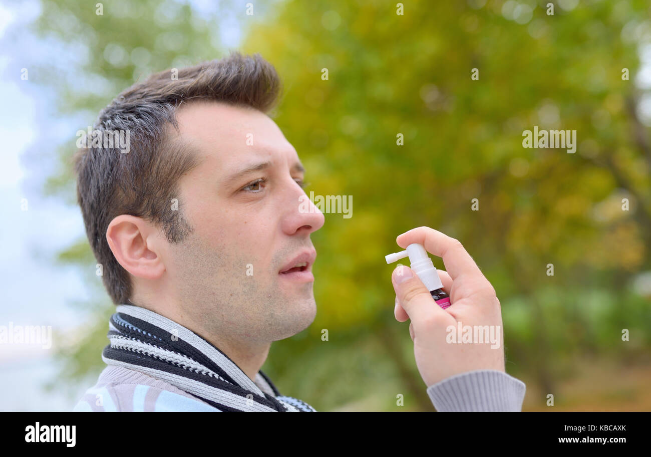 Man spraying with nasal spray in autumn time Stock Photo - Alamy
