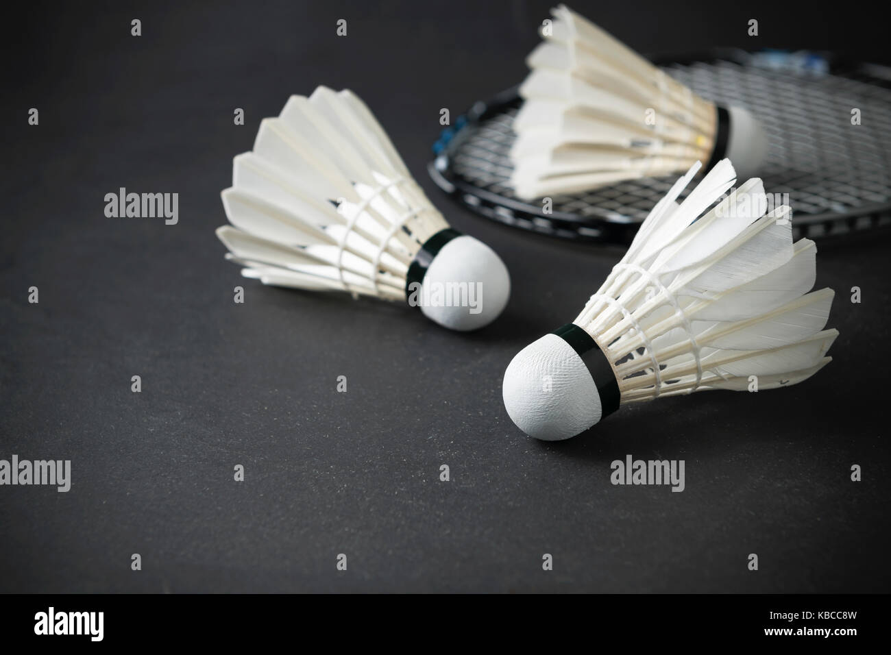 Shuttlecocks and badminton racket on black background.Sport concept ...