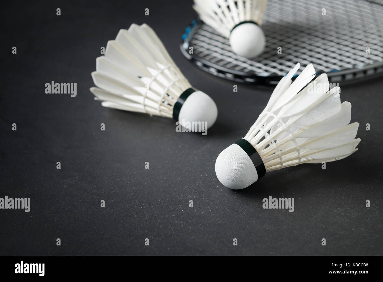 Shuttlecocks and badminton racket on black background.Sport concept ...