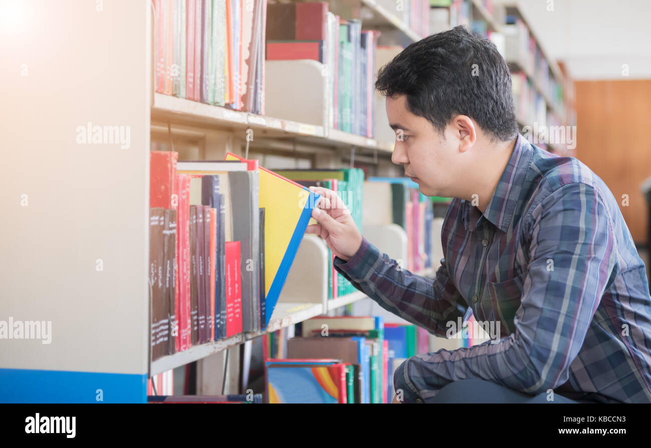 smart student find book on bookshelf in library, education concept ...