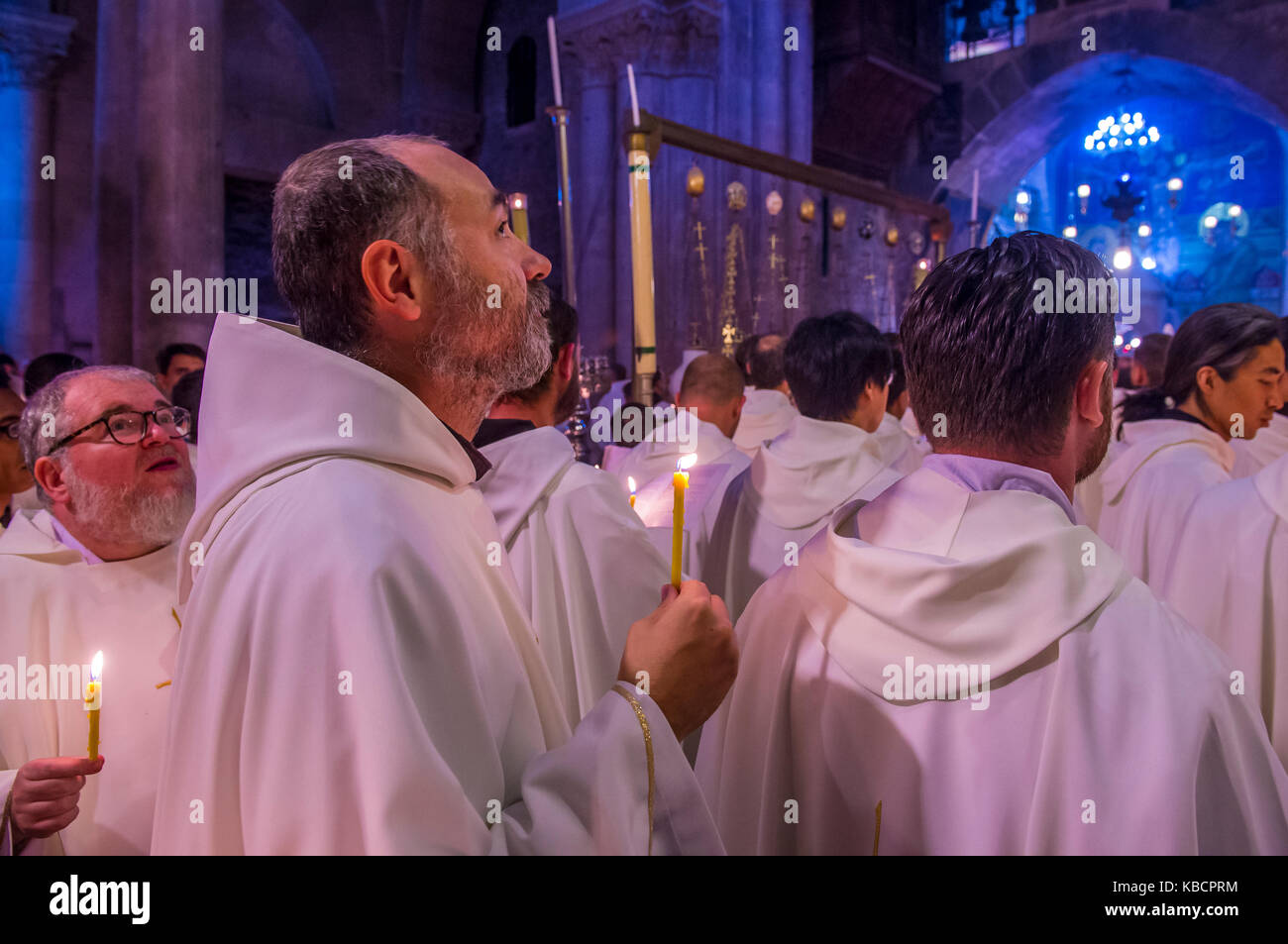 A procession of monks holding candels during Easter in the church of ...