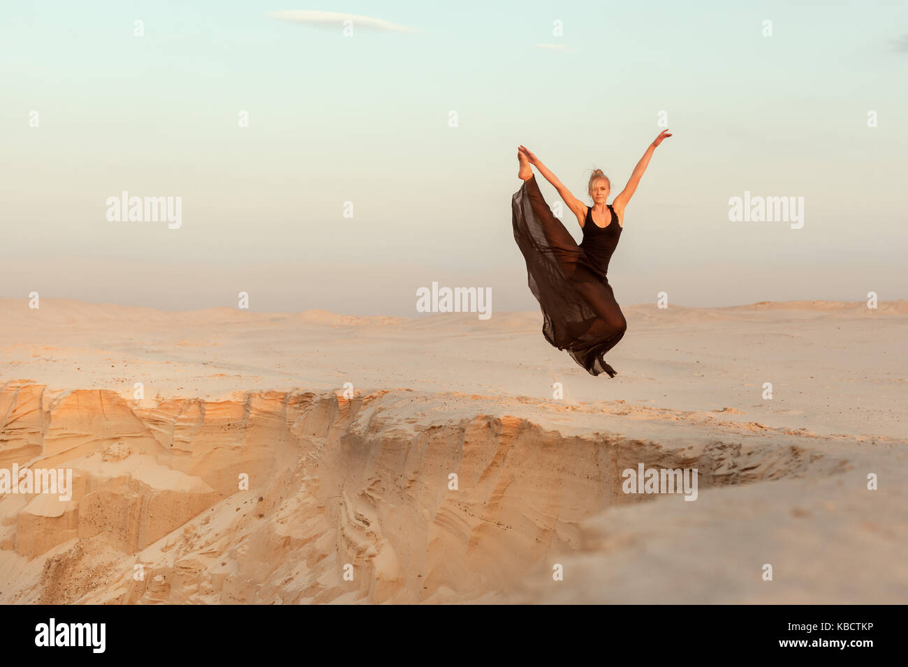Woman in dance flies over an abyss in the desert Stock Photo - Alamy