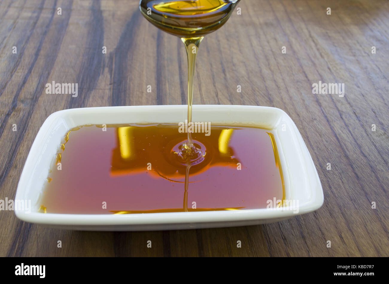 honey dripping on wooden table Stock Photo - Alamy