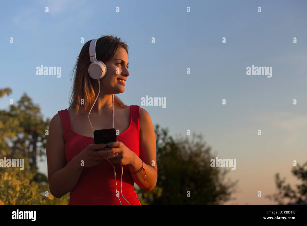 beautiful casual woman enjoying music at the sunset, with headphones ...