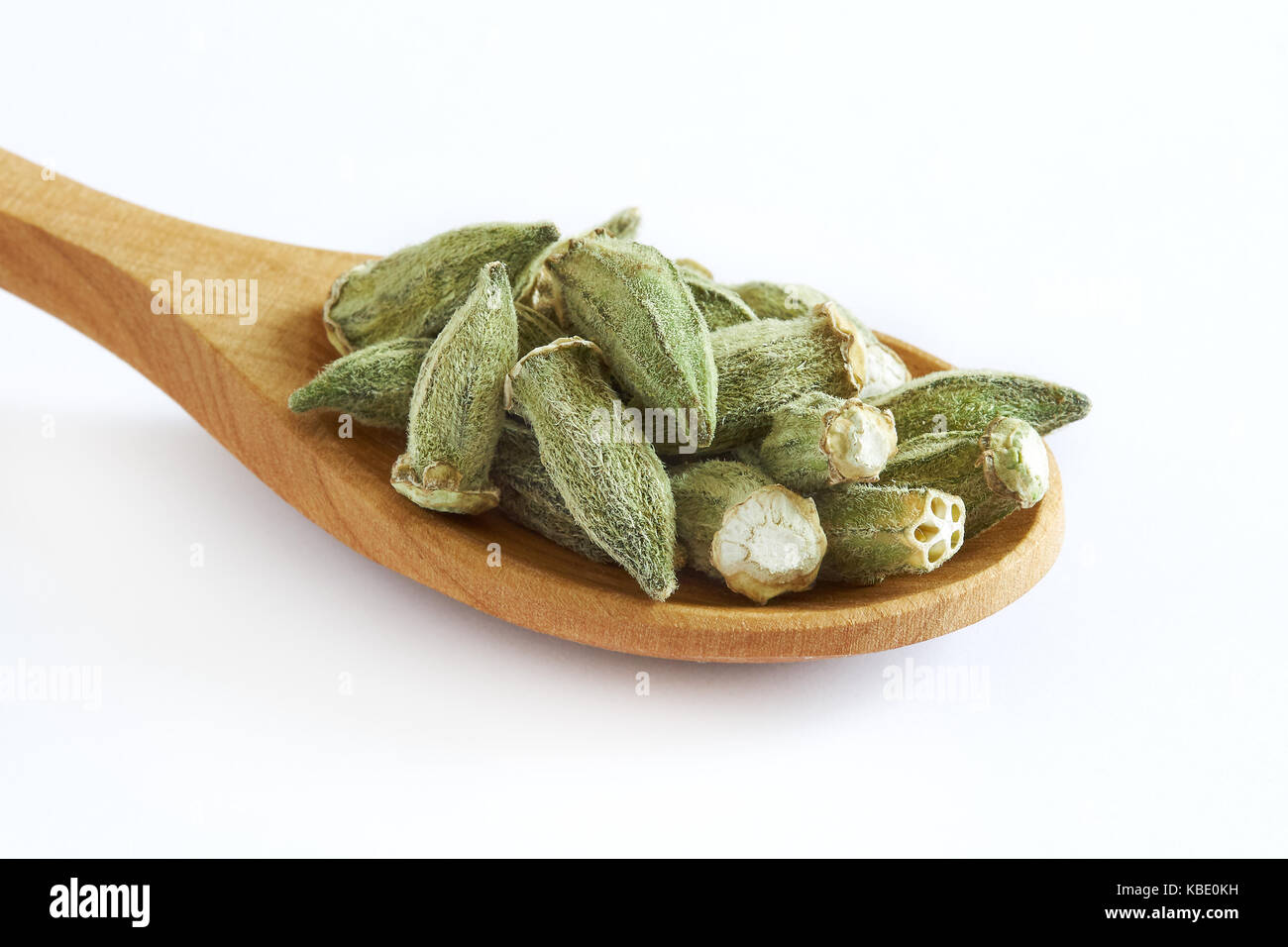Dried okra (ladies' fingers, ochro) in wooden spoon isolated on white ...