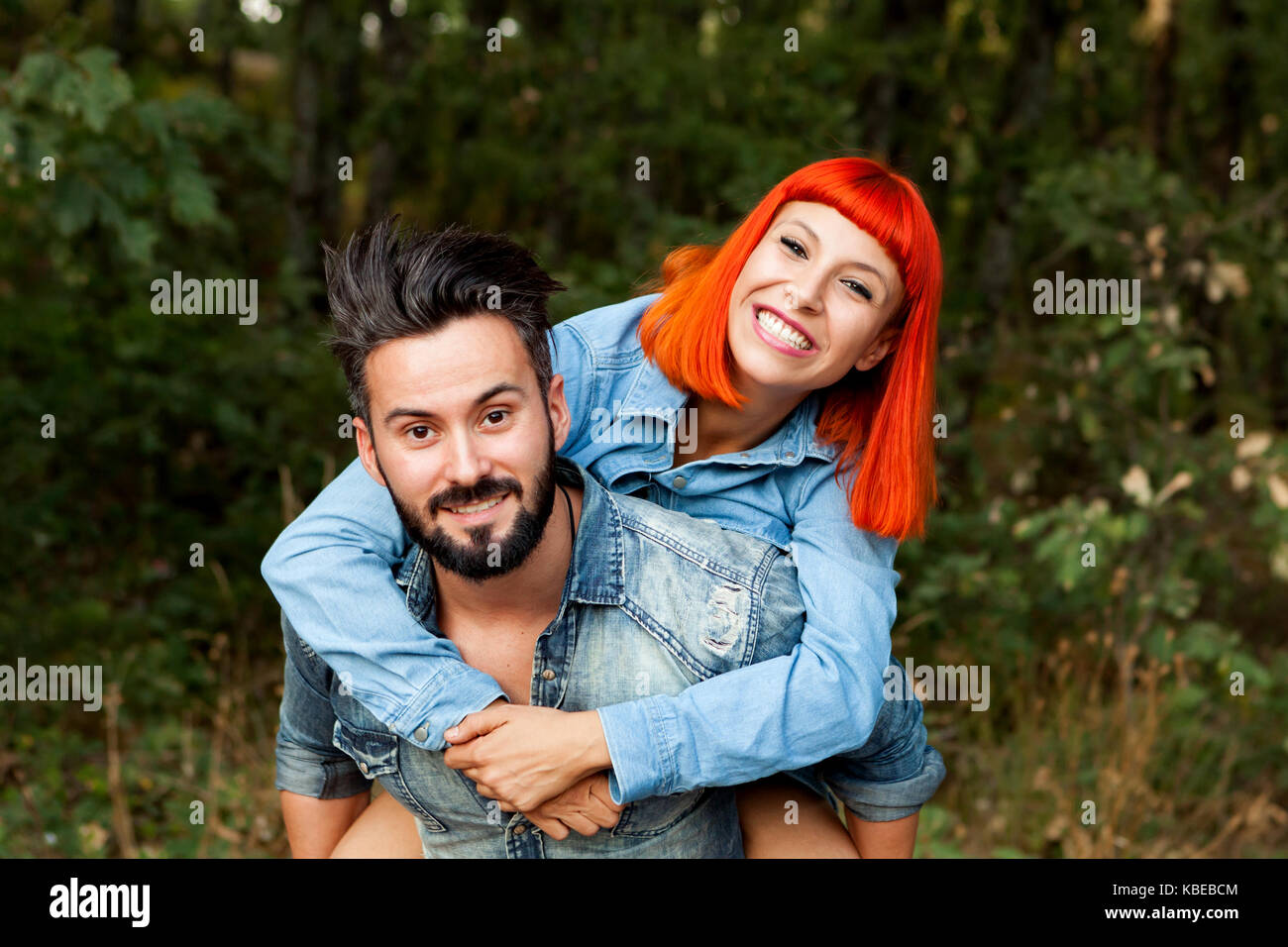 Handsome guy giving piggyback ride to girlfriend in a park Stock Photo ...
