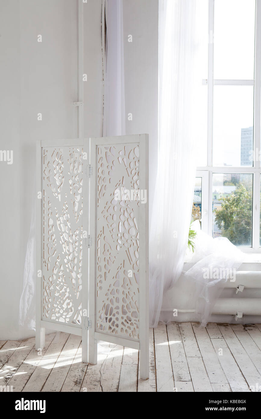 White patterned screen on a wooden floor in a white room in the ...