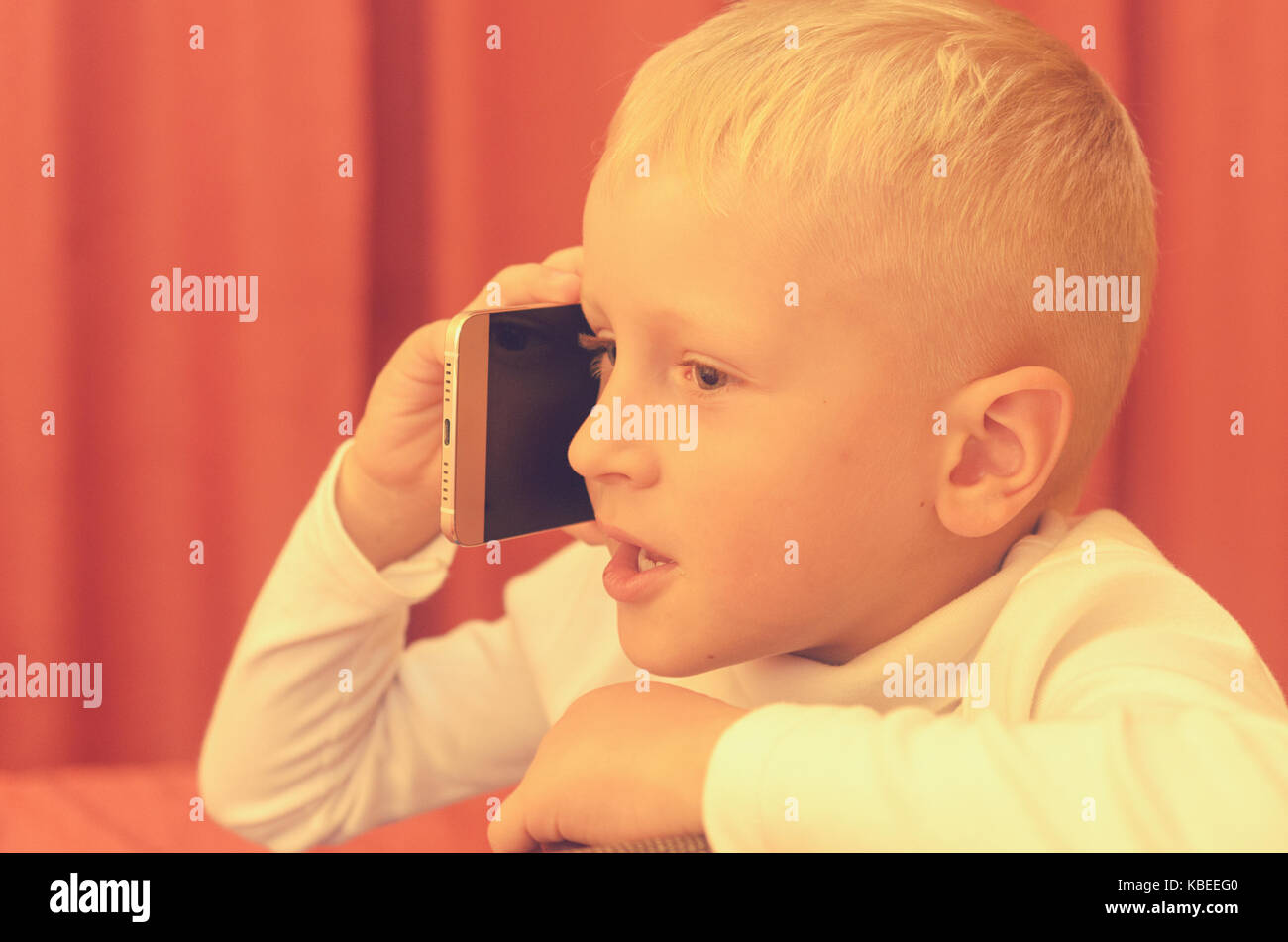 Little boy talking on the phone expressing his emotions Stock Photo - Alamy