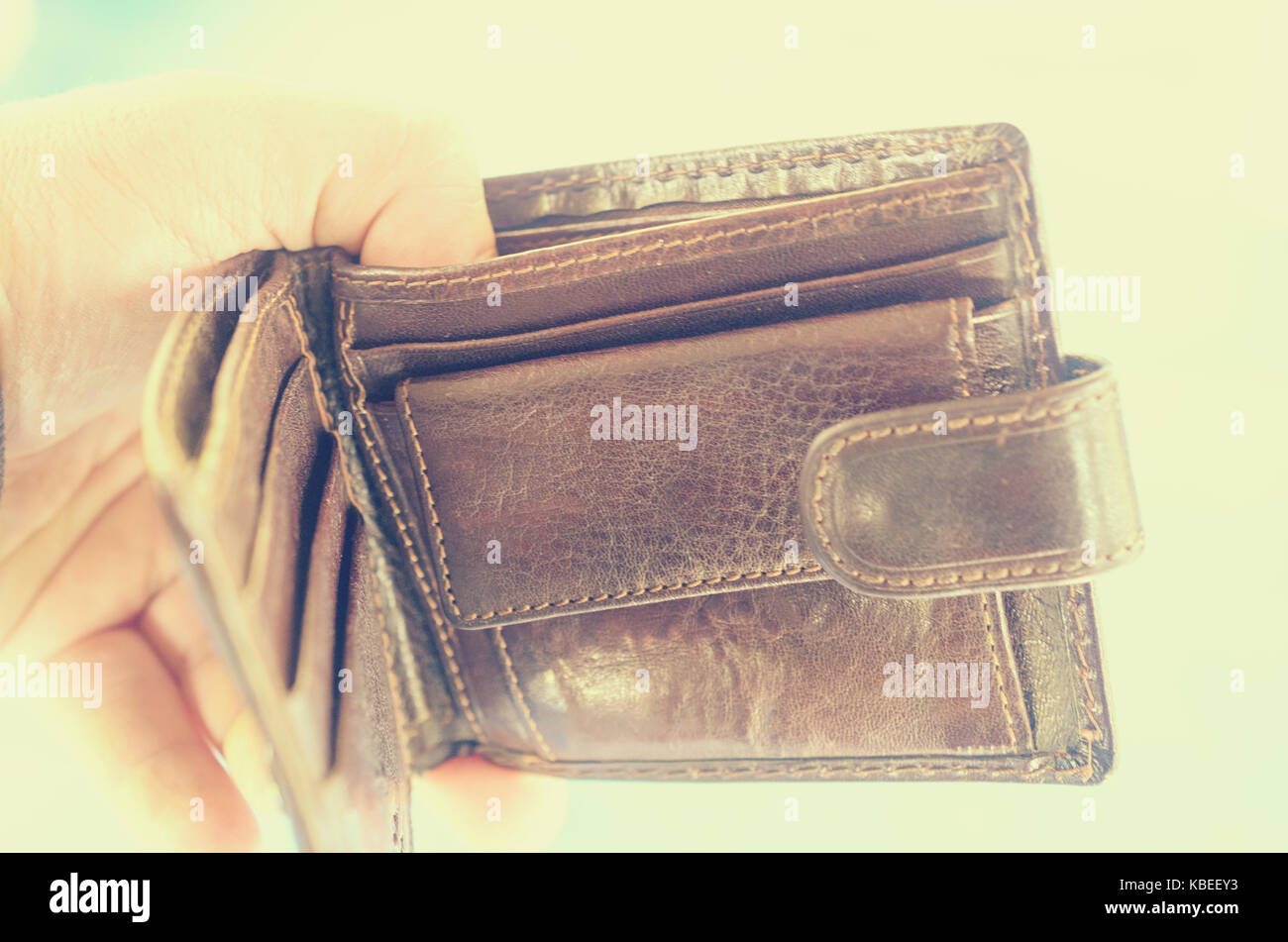 Empty open brown purse in one hand Stock Photo - Alamy