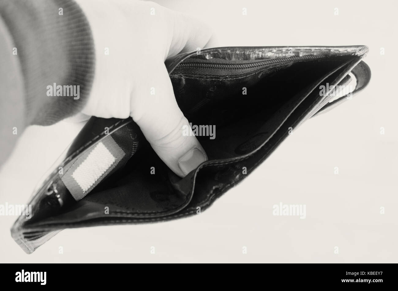 Empty open brown purse in one hand Stock Photo - Alamy