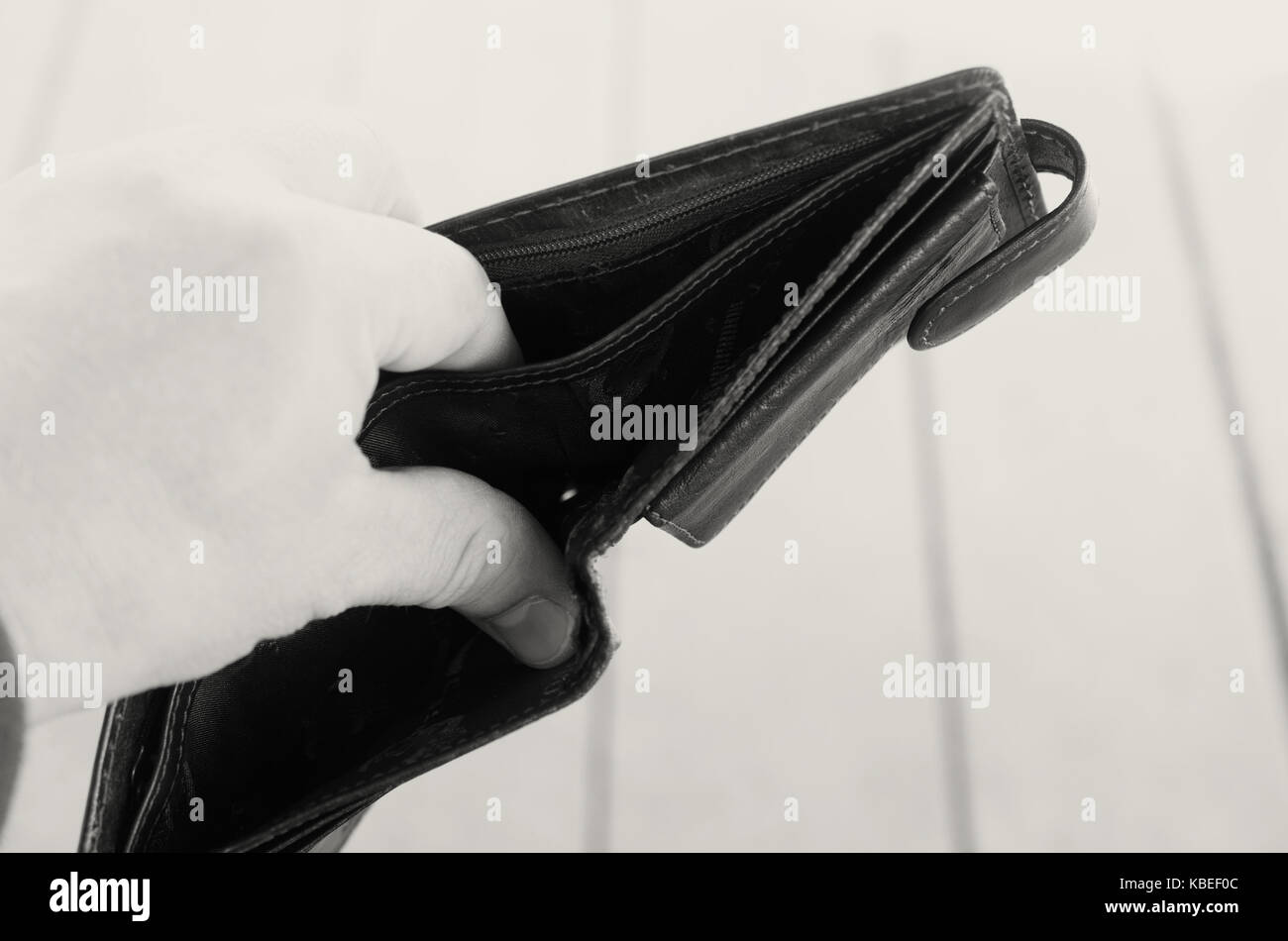 Empty open brown purse in one hand Stock Photo - Alamy