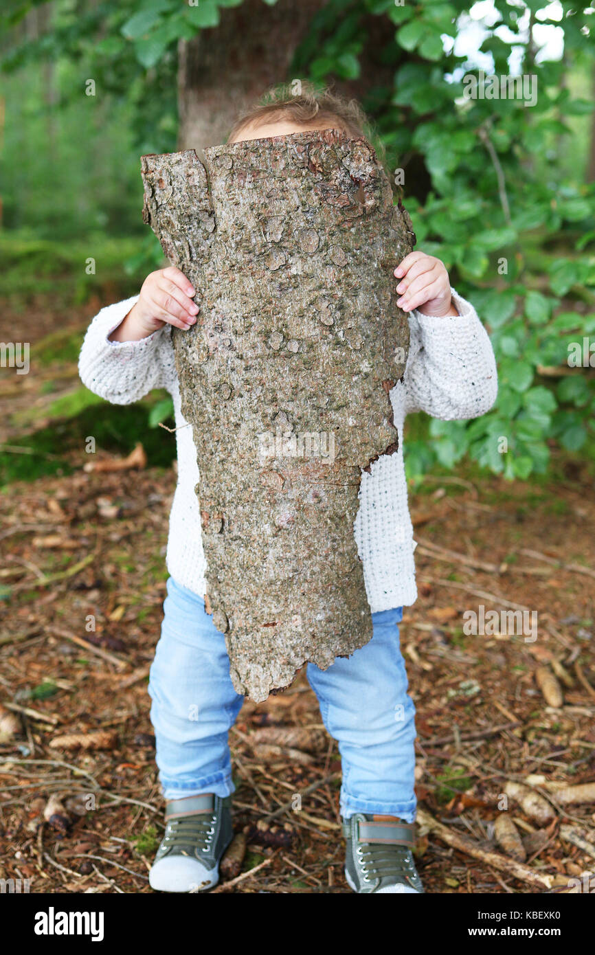Happy child playing in a forest Stock Photo - Alamy