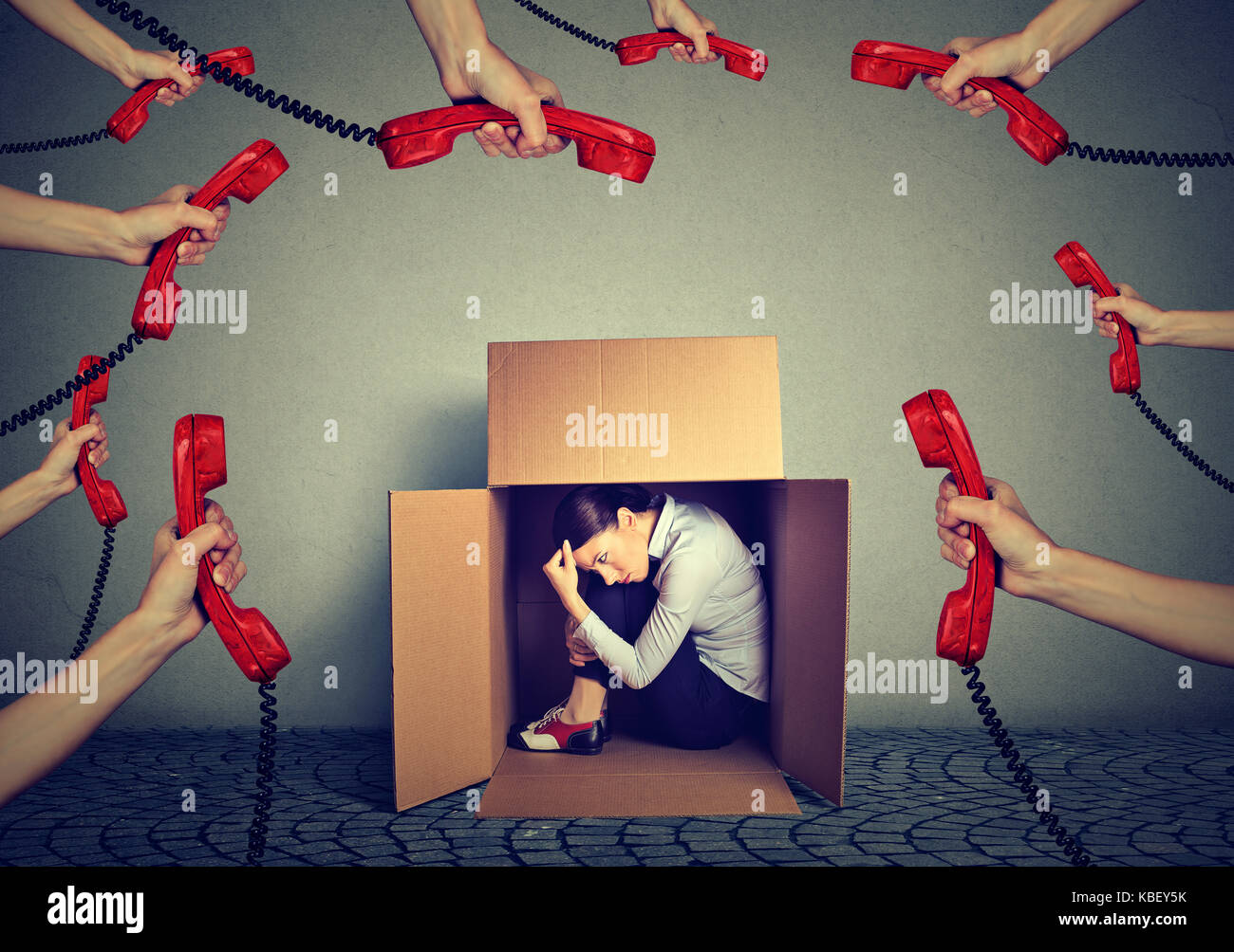 Stressed young business woman sitting hiding in a box overwhelmed by ...