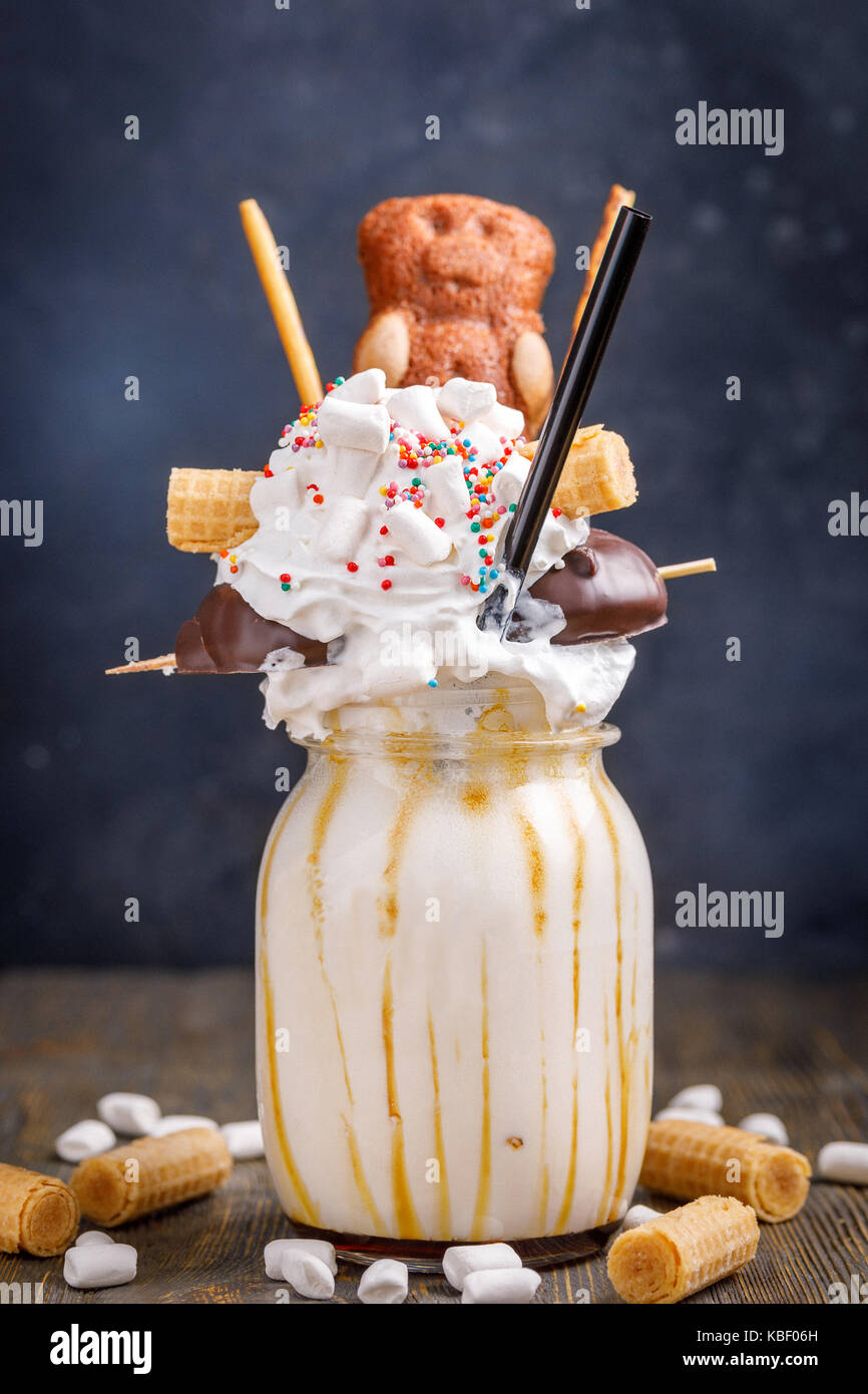Unusual milkshake decorated with candies, marshmallows, whipped cream ...