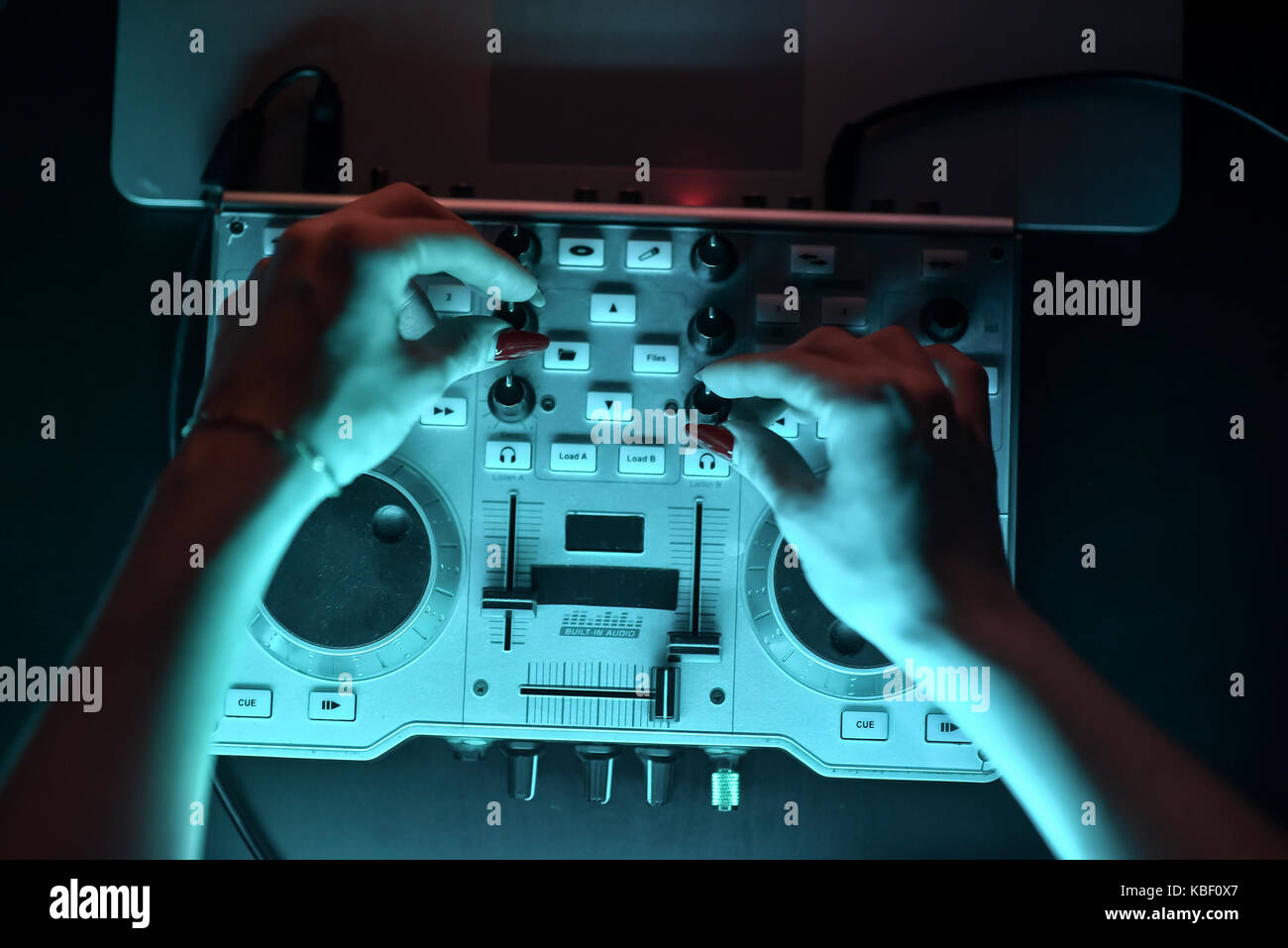 DJ mixer disco illuminated by searchlights Stock Photo - Alamy