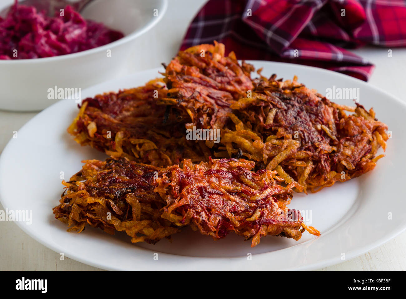 beetroot and potato rosti on white plate and table Stock Photo - Alamy